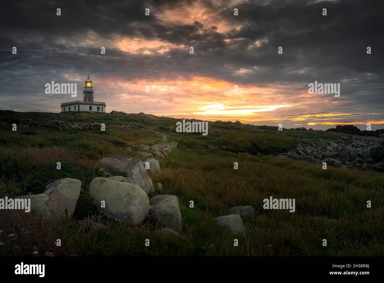Glorious sunset with a spectacular sky and a lighthouse on the horizon ...