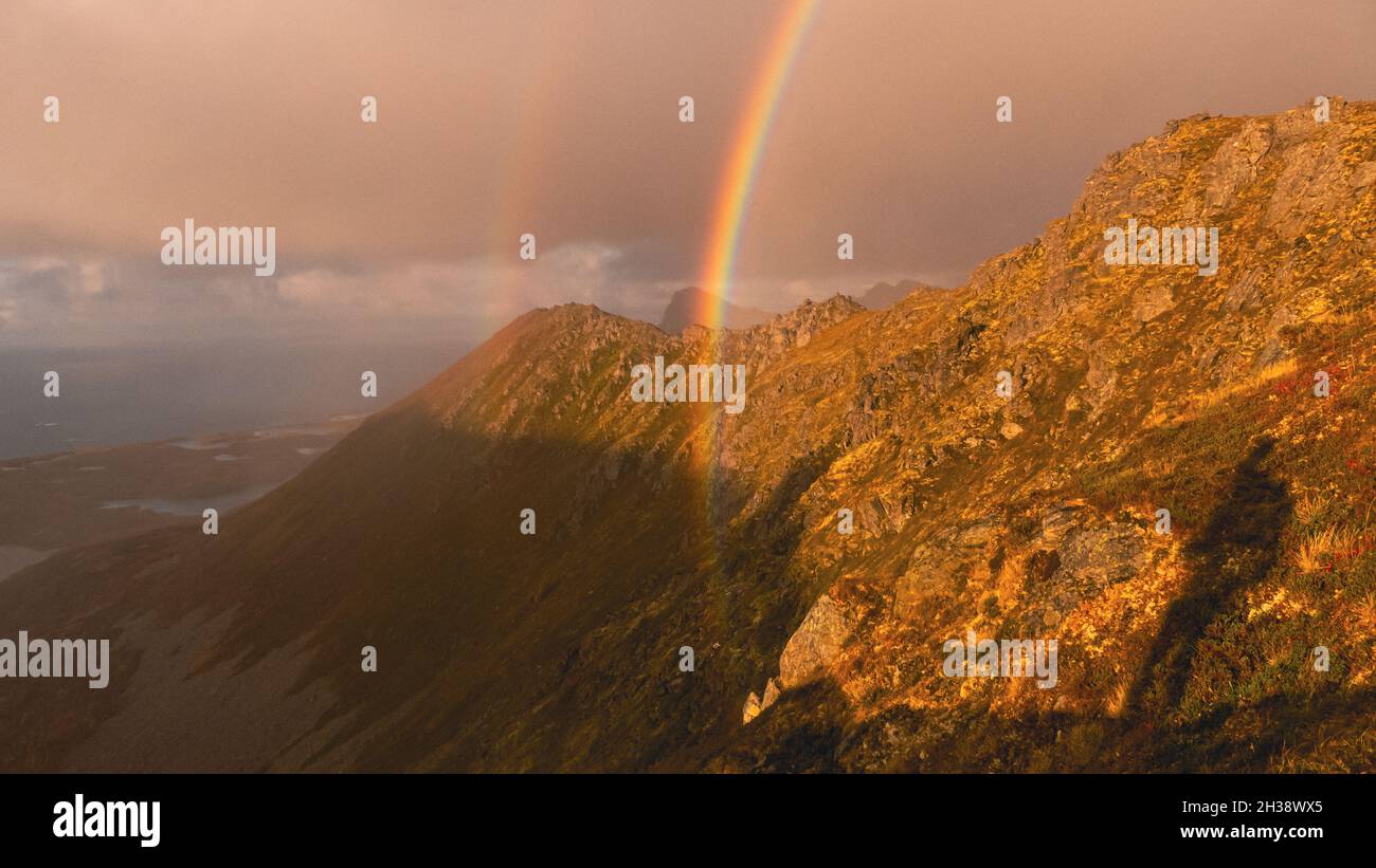 Beautiful panoramic view of a rainbow in the mountains under sunlight ...