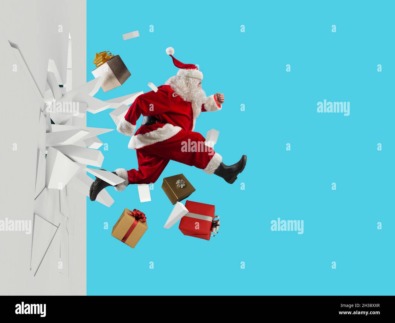 Santa claus full of gifts exits breaking a wall Stock Photo - Alamy