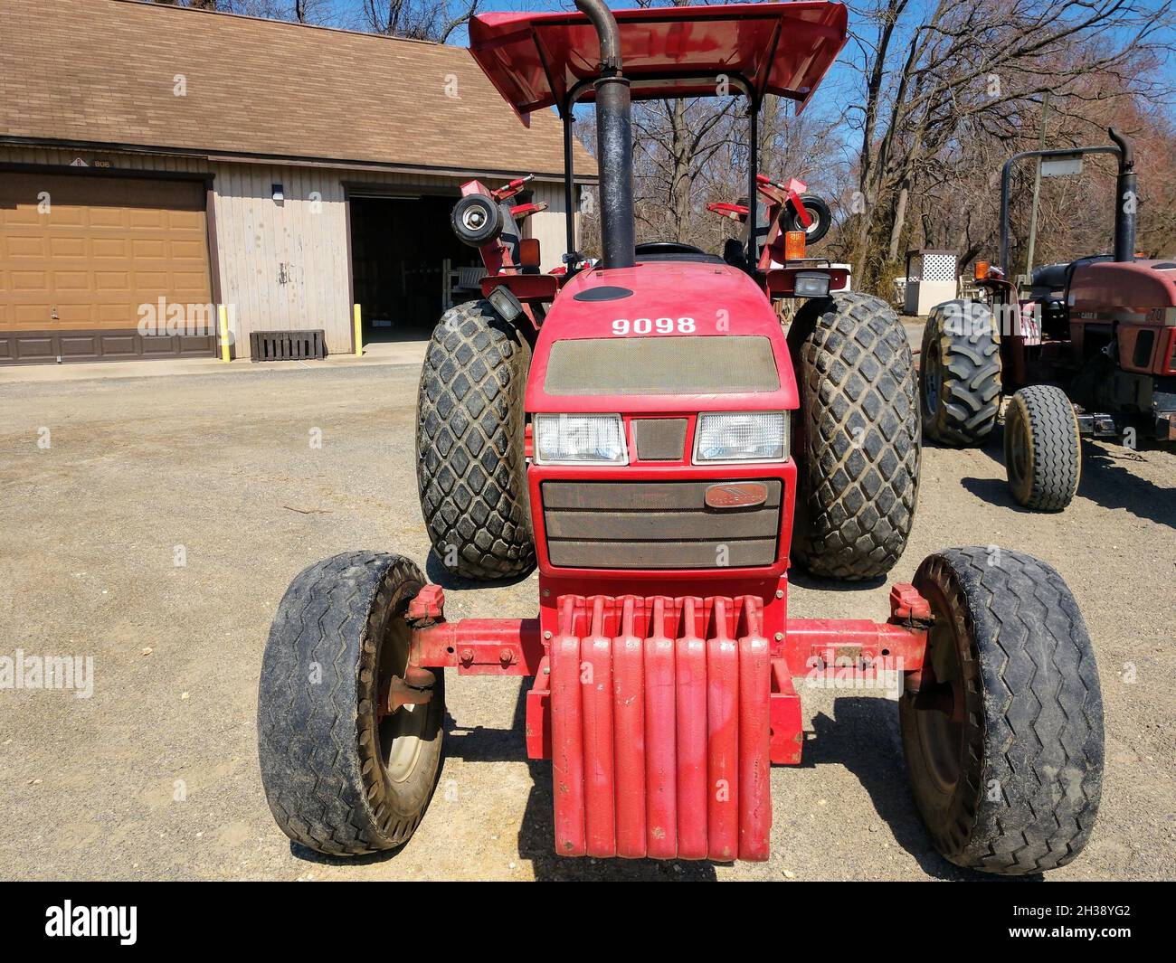 Dirty tractor in front of a garage Stock Photo - Alamy