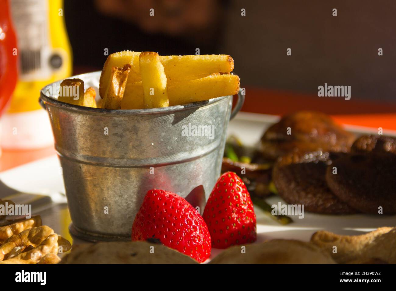Silver steel small bucket full of french fries with strawberries ...