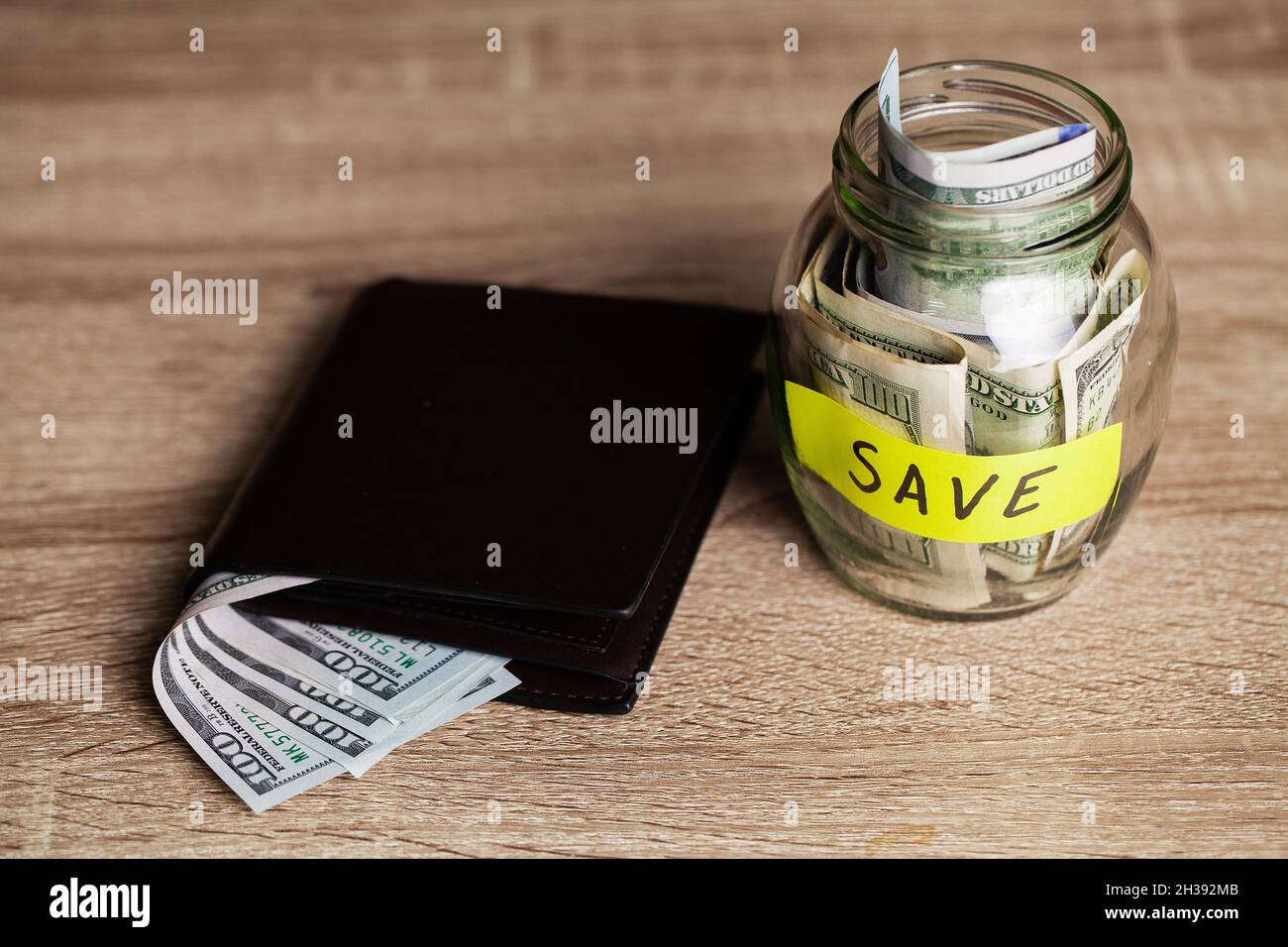 Dollar bills in glass jar on wooden table Stock Photo - Alamy