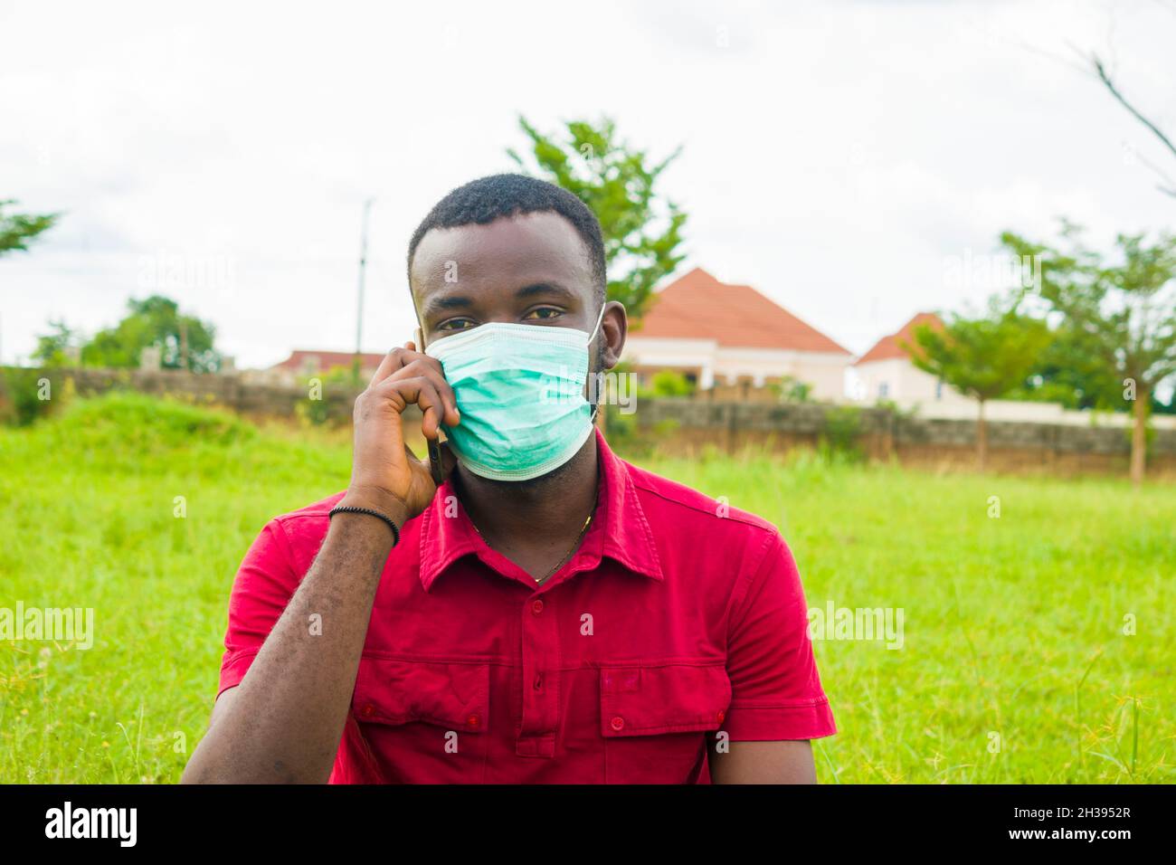 young handsome african man wearing face mask making calls with his ...