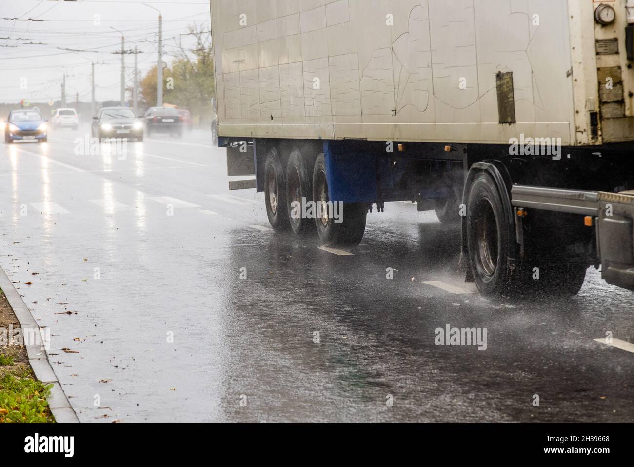 dry van trailer truck moving on a wet road with splashes during the day ...