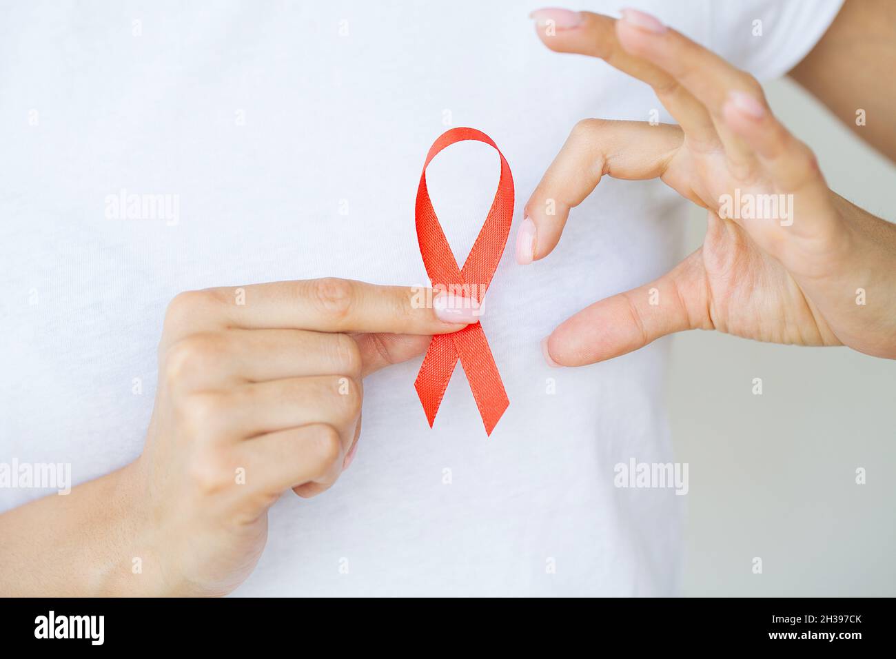 Woman hand holding red ribbon HIV, world AIDS day awareness ribbon ...