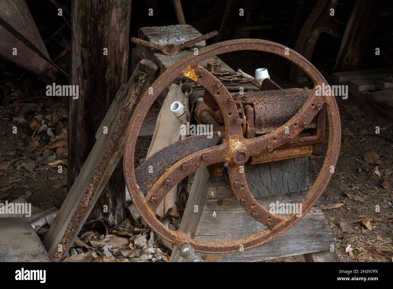 An old rusted iron wheel placed against other vintage objects at an ...