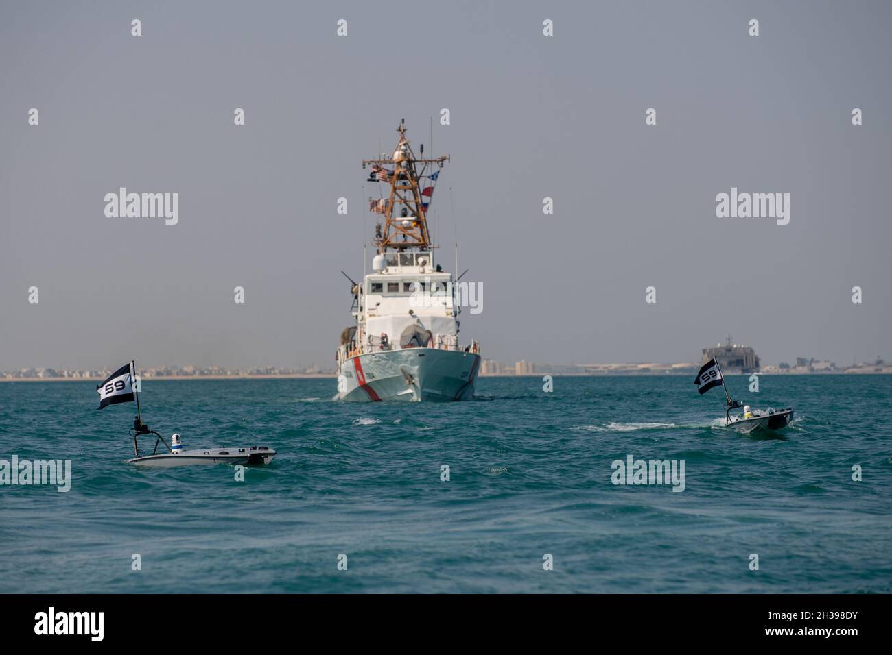 Two MANTAS T-12 unmanned surface vessels (USV), front, operate alongside U.S. Coast Guard patrol ...