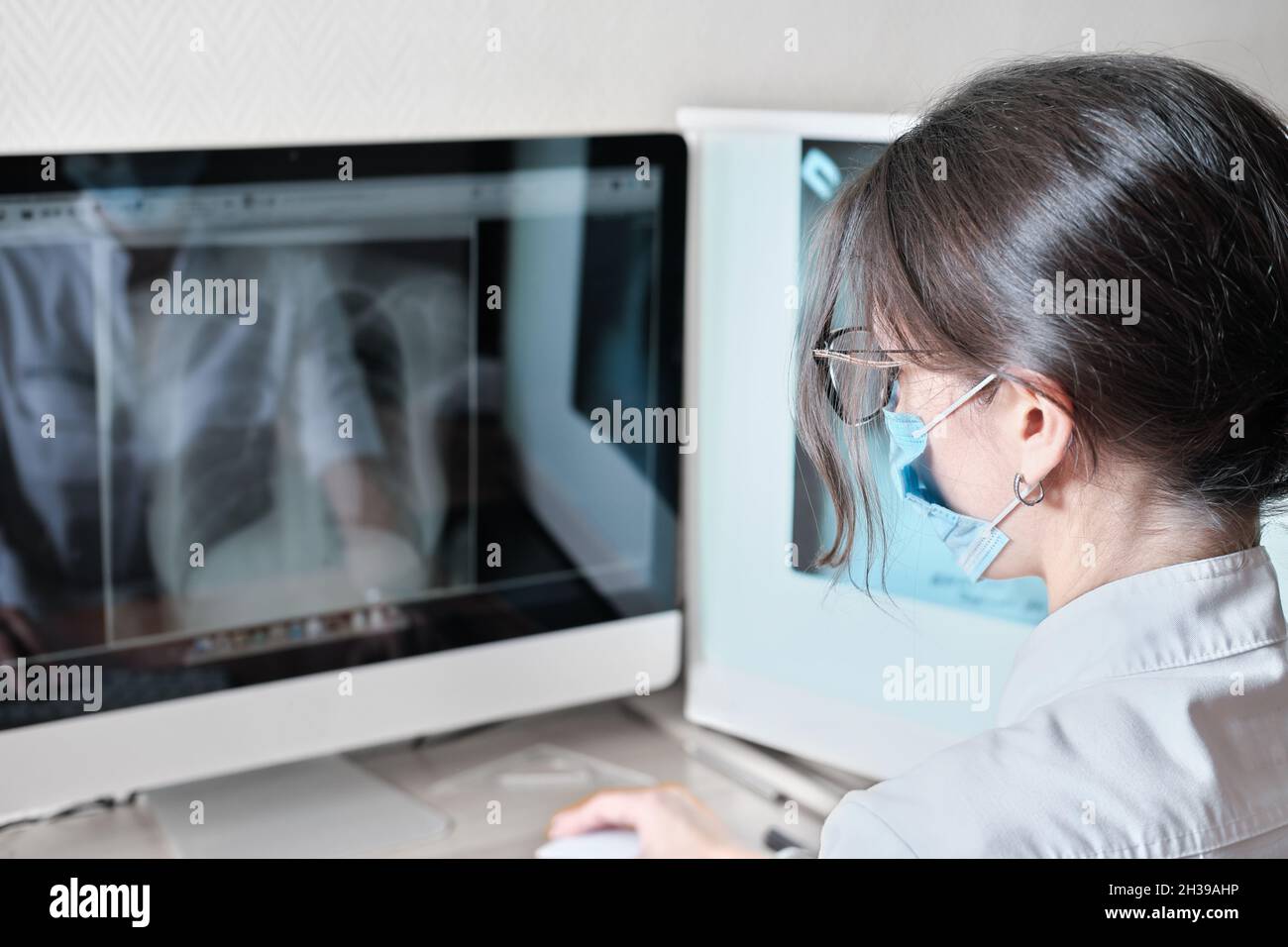 Young asian woman radiologist doctor analysis pulmonary x-ray and make ...