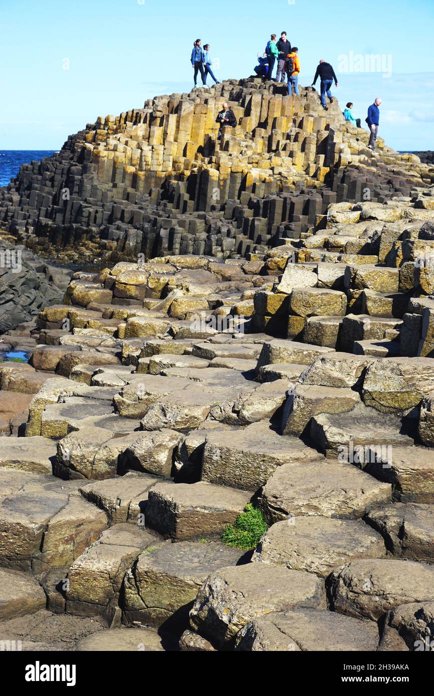 Visitors climb to the top of natural volcanic rock formations at the ...