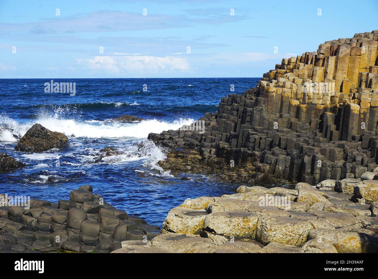 Waves crash ashore over the natural volcanic basalt rock formations at ...