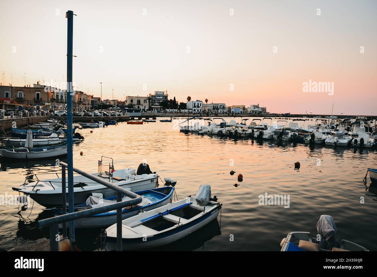 Scenic view of boats moored on a calm coast under a beautiful sunset ...