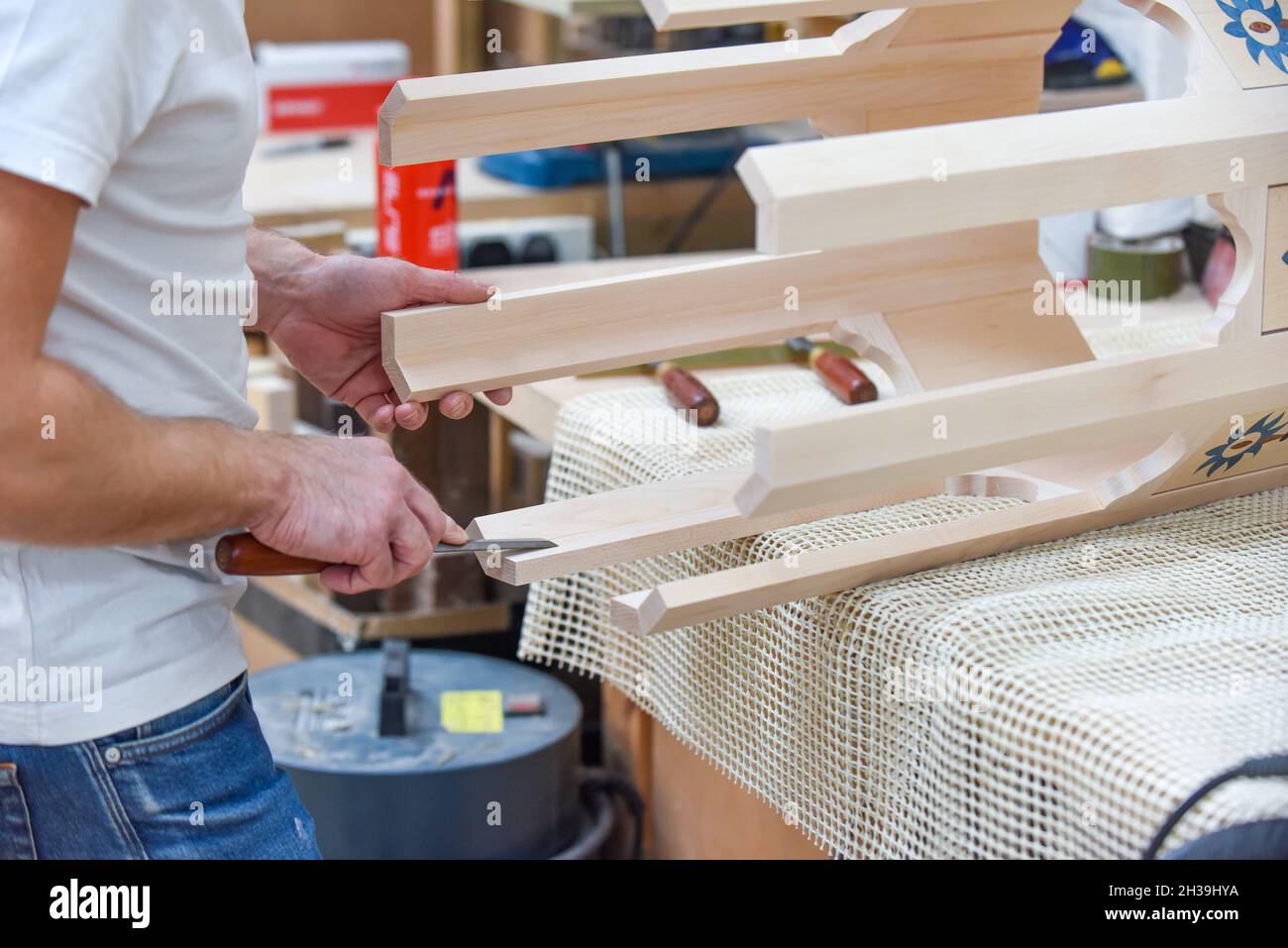 Man is using a chisel to shape and carve wood in carpentry Stock Photo ...