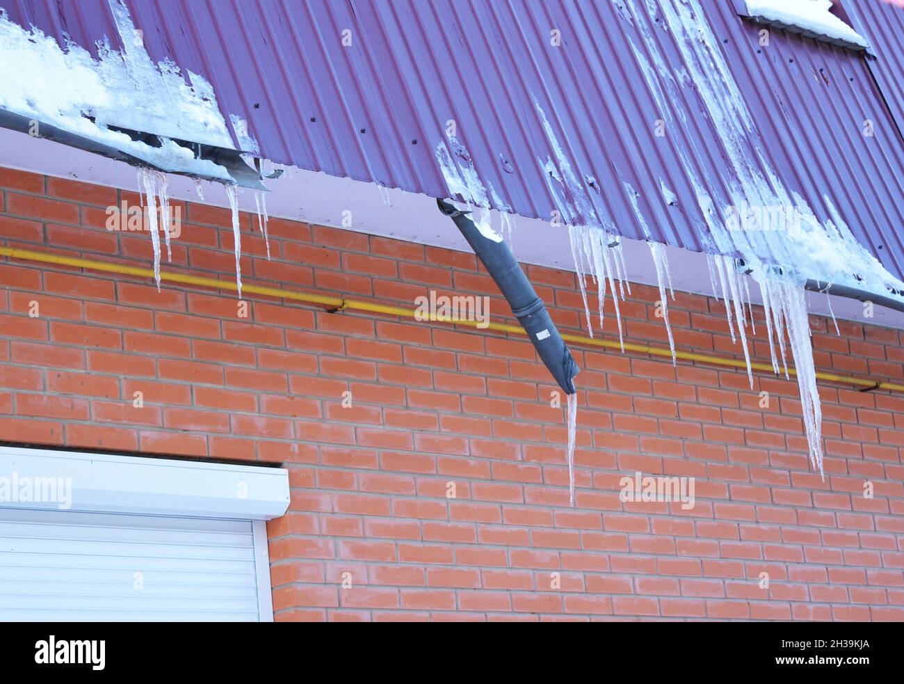 Broken Rain Gutters. Ice dam. Closeup on new broken rain gutter system ...