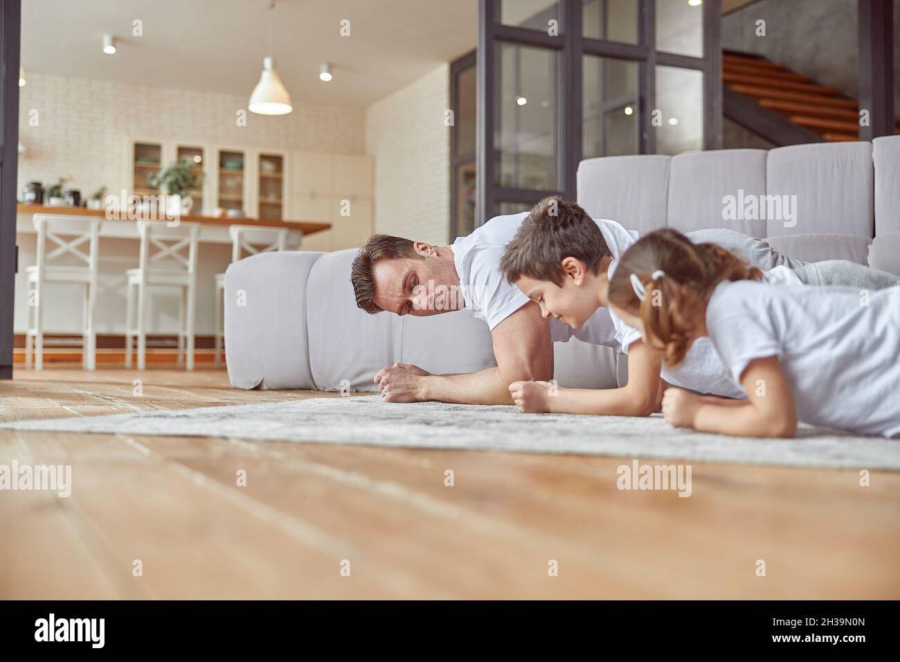 Father teaching kids doing plank position at home Stock Photo - Alamy