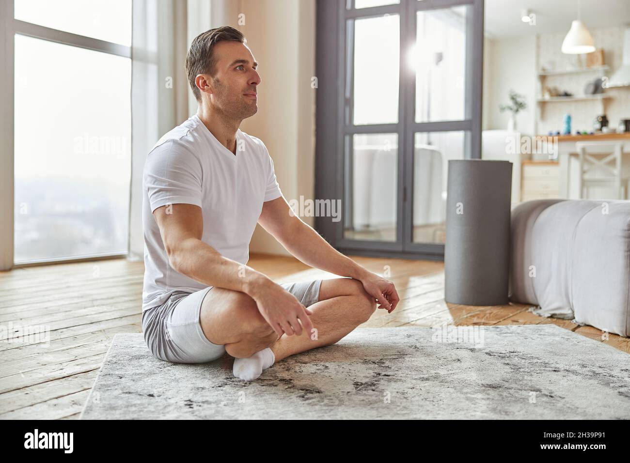 Calm male practicing meditation alone at home Stock Photo - Alamy