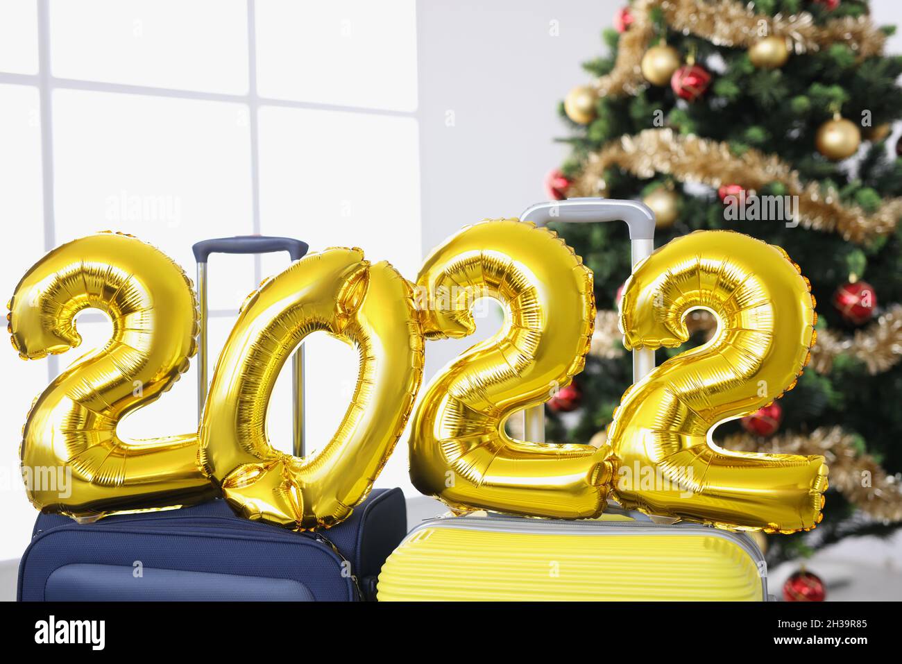 Golden helium balloons with numbers 2022 standing on suitcases ...