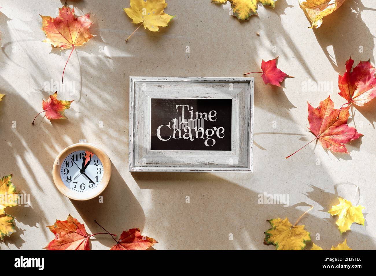 Time change in Autumn. Wooden alarm clock with one hour mark with dry ...