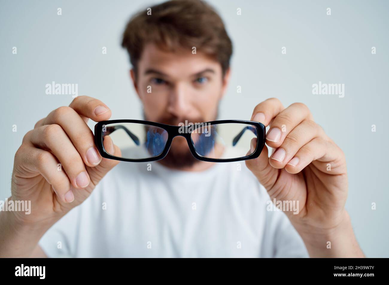 bearded man vision problems in white t-shirt isolated background Stock ...