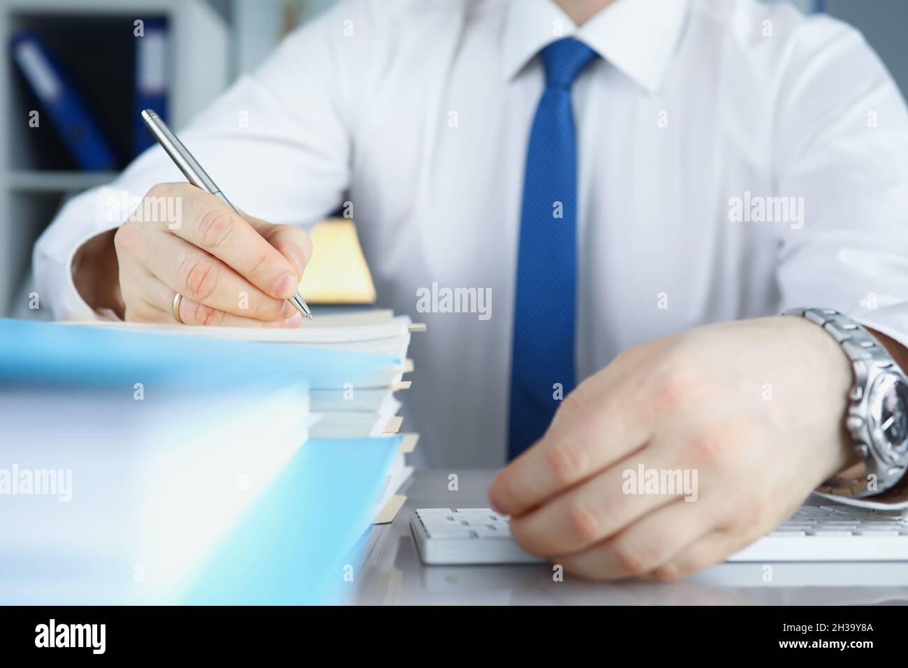 Employee in suit with stack of papers Stock Photo - Alamy