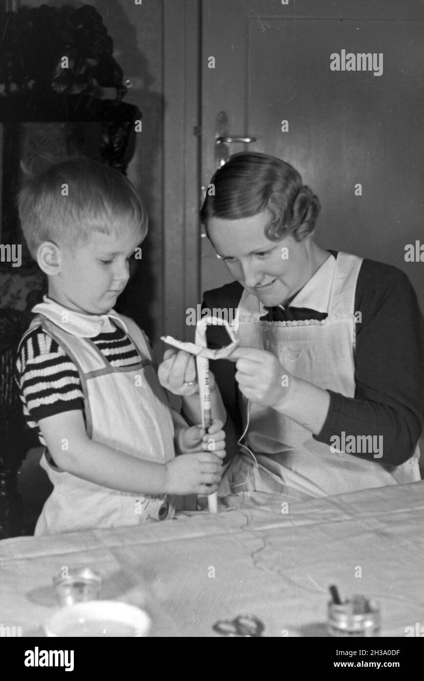 Mutter und Kind beim basteln, Deutschland 1930er Jahre. Mother and ...