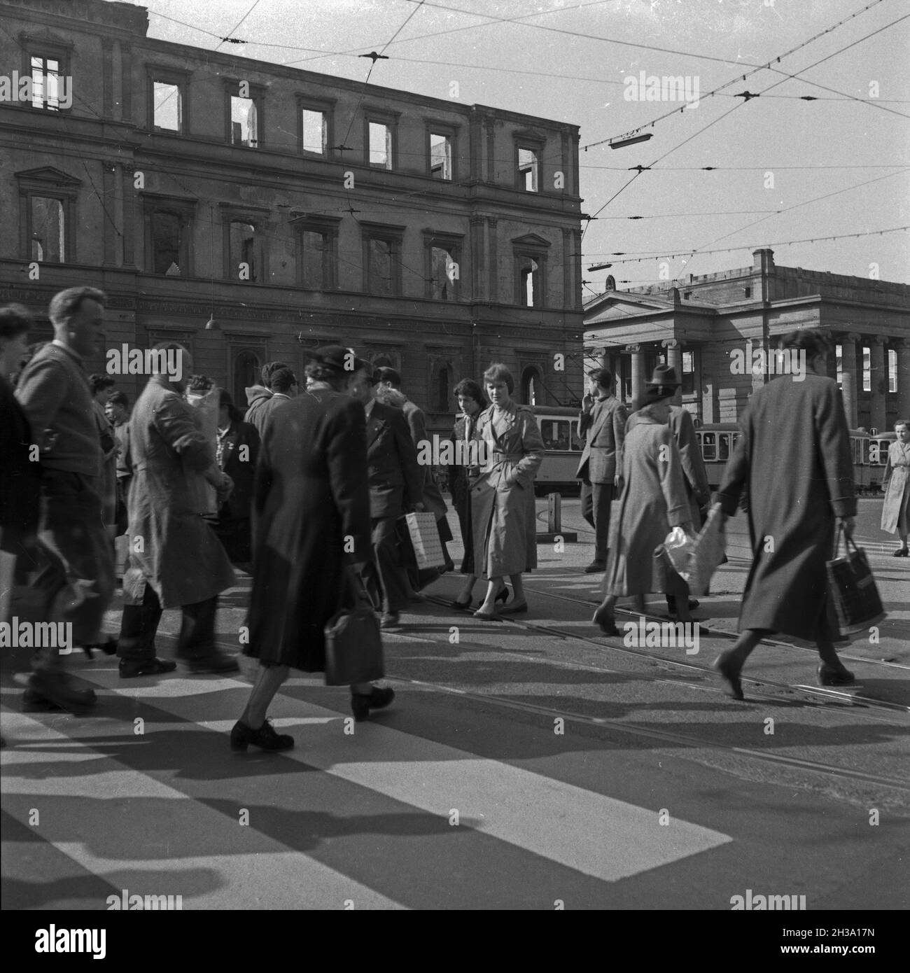Passanten überqueren eine Straße in der Innenstadt von Stuttgart ...