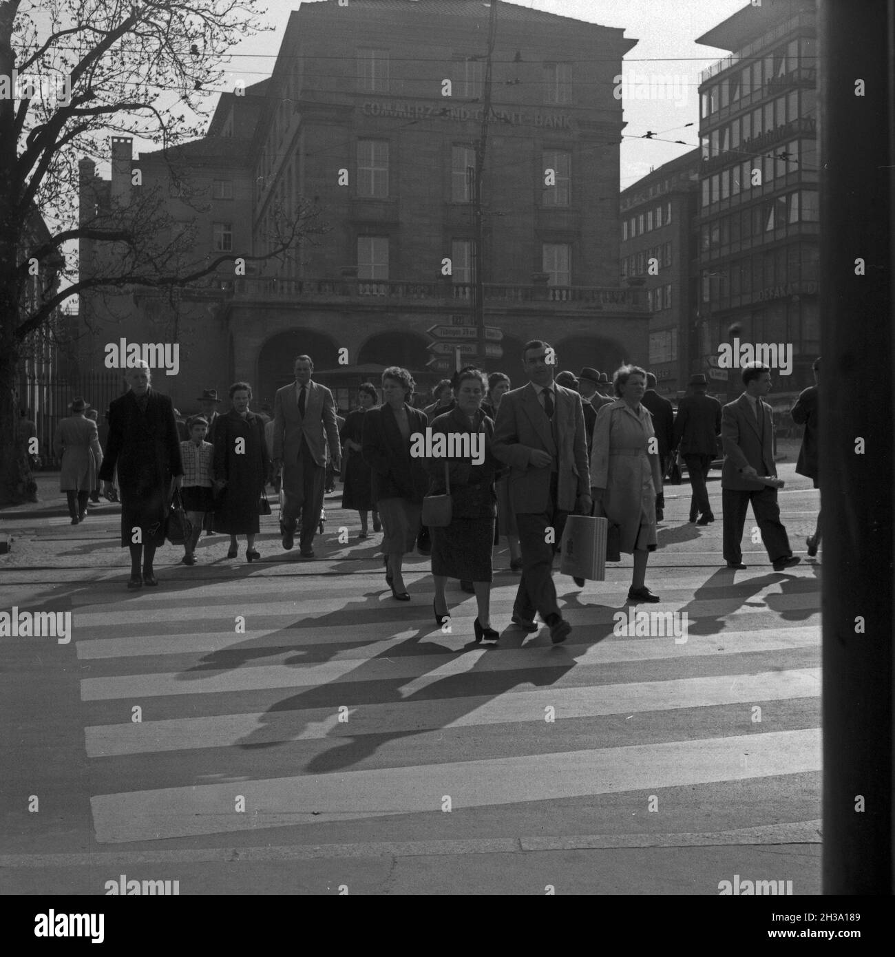 Passanten überqueren eine Straße in der Innenstadt von Stuttgart ...