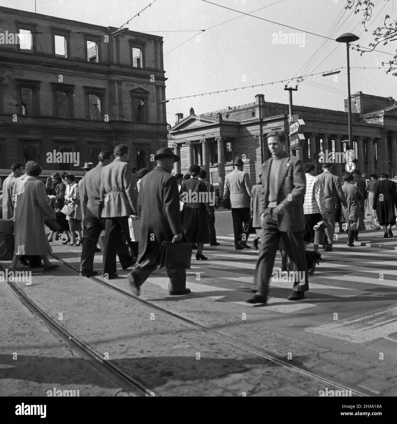 Passanten überqueren eine Straße in der Innenstadt von Stuttgart ...
