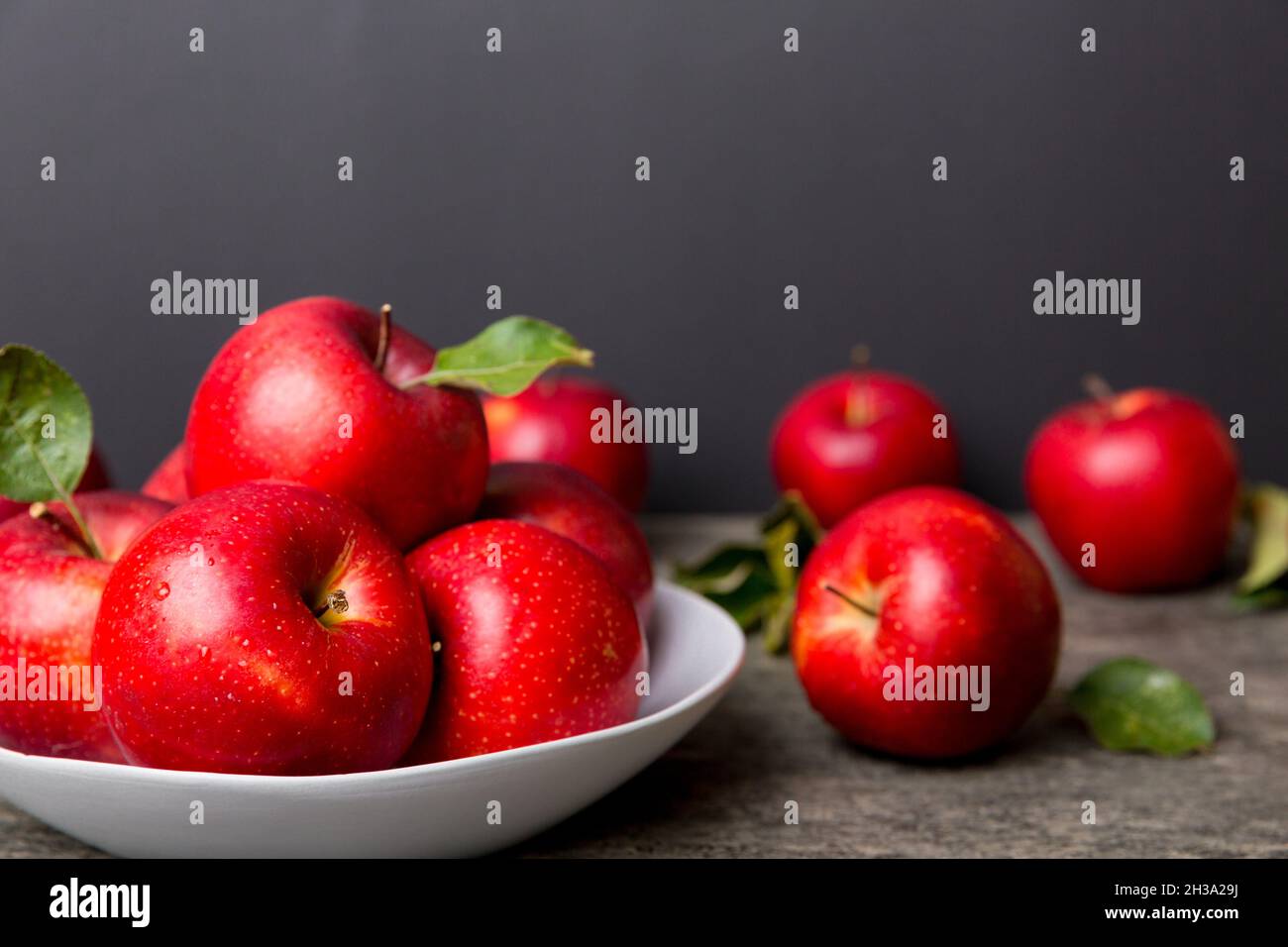 juicy red apples in a bowl or plate on the table top view. Copy space ...
