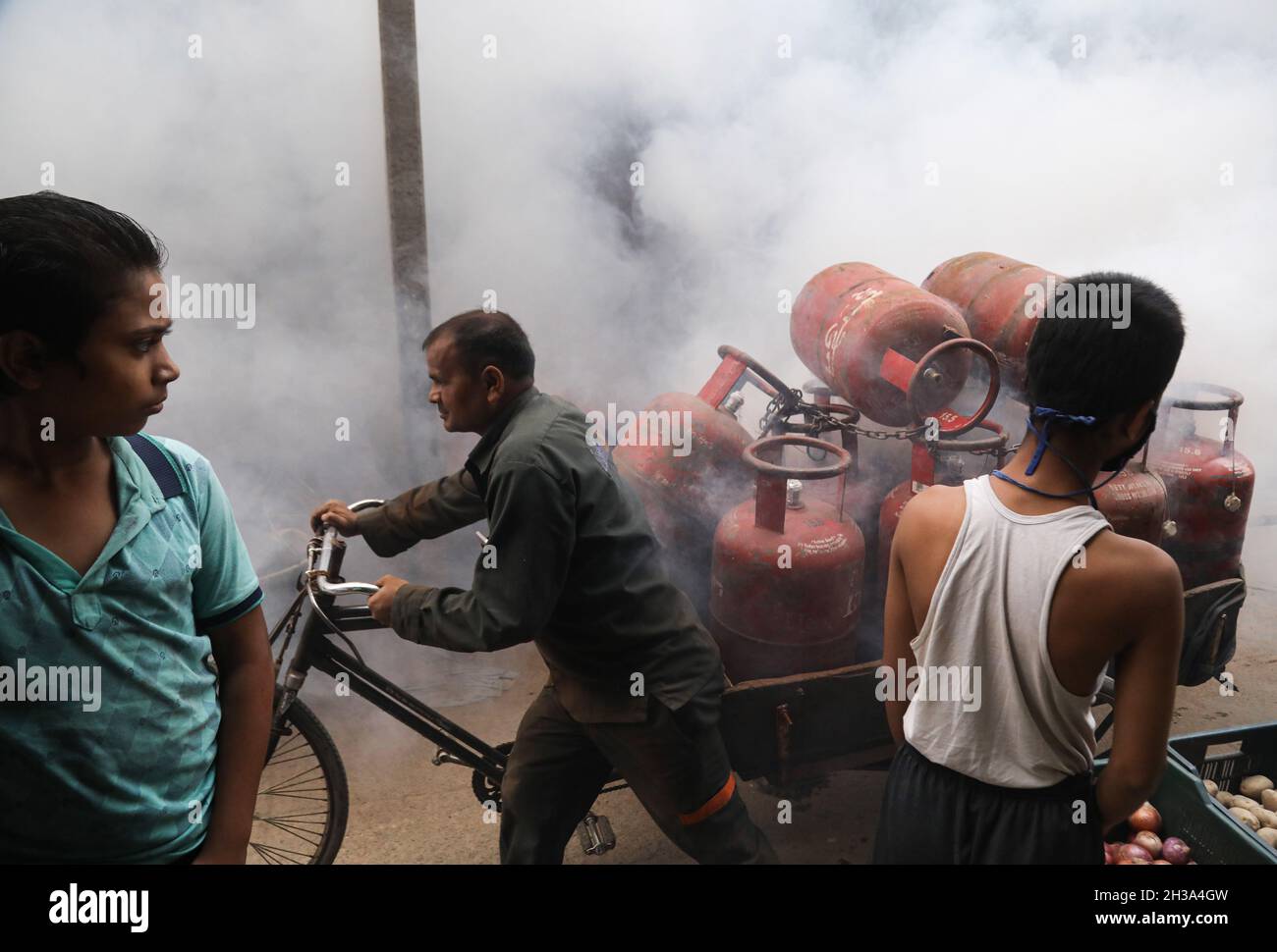 New Delhi, India. 27th Oct, 2021. A worker rides his load of gas ...