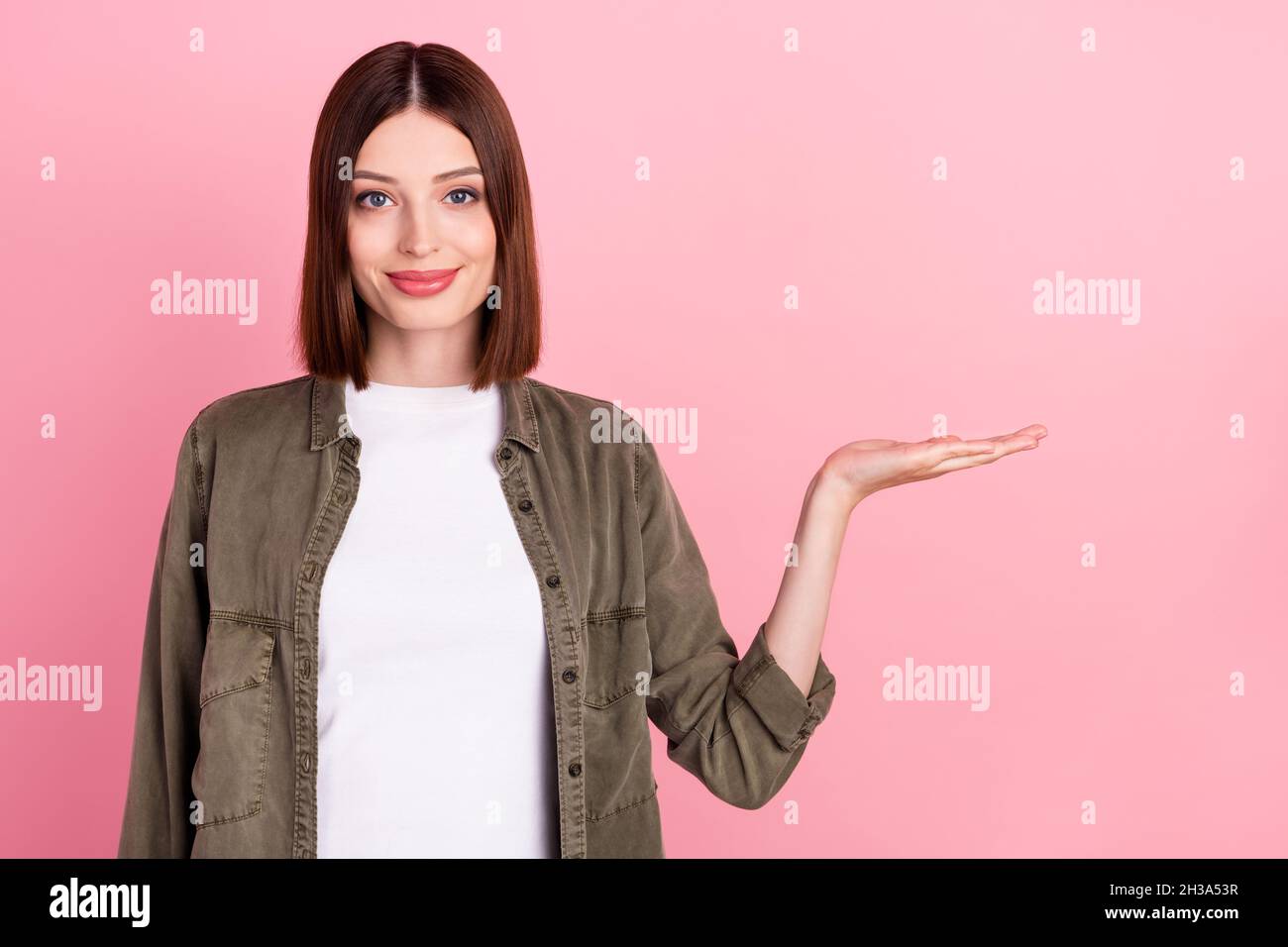 Photo of optimistic bob hairdo millennial lady hold empty space wear khaki shirt isolated on ...