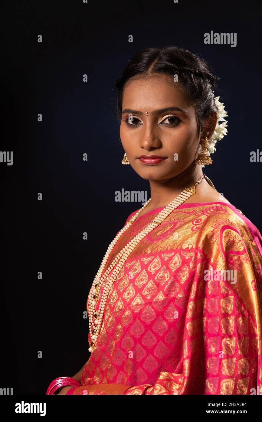 Indian female model in traditional red Saree attire. Black background ...