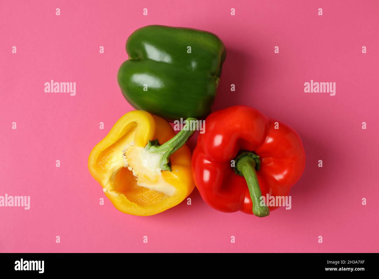 Multi-colored bell pepper on pink background Stock Photo - Alamy