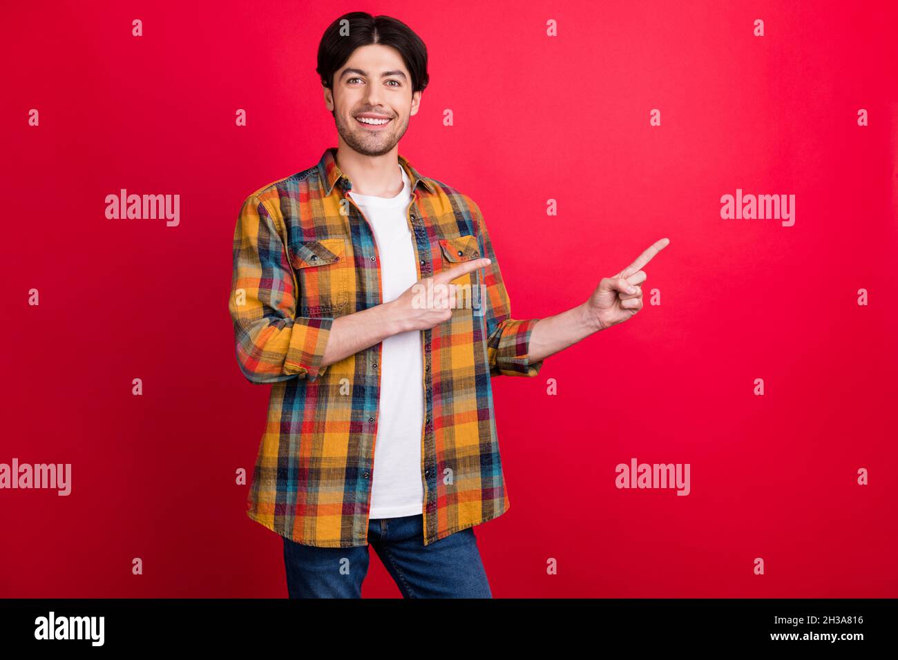 Photo of cute charming young guy dressed checkered clothes pointing ...