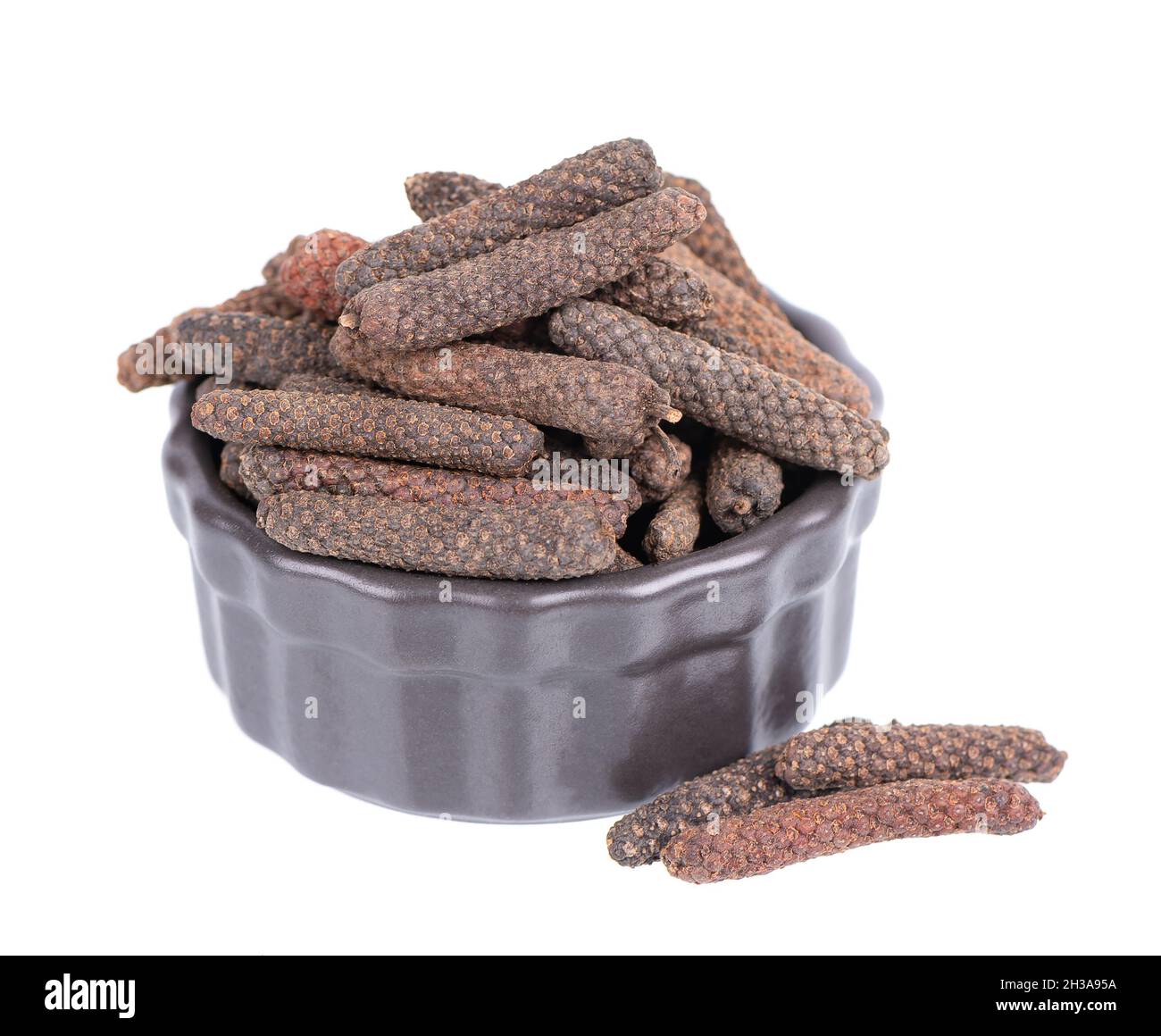 Long pepper in black bowl, isolated on white background. Heap of ...