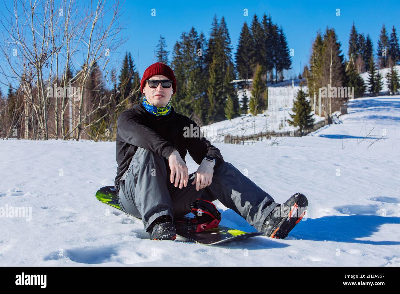 man sitting on snowboard resting Stock Photo - Alamy