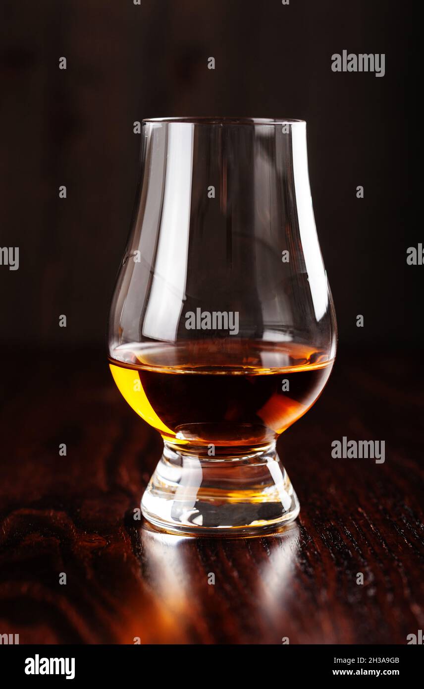 glass of whisky spirit brandy on dark brown background Stock Photo - Alamy
