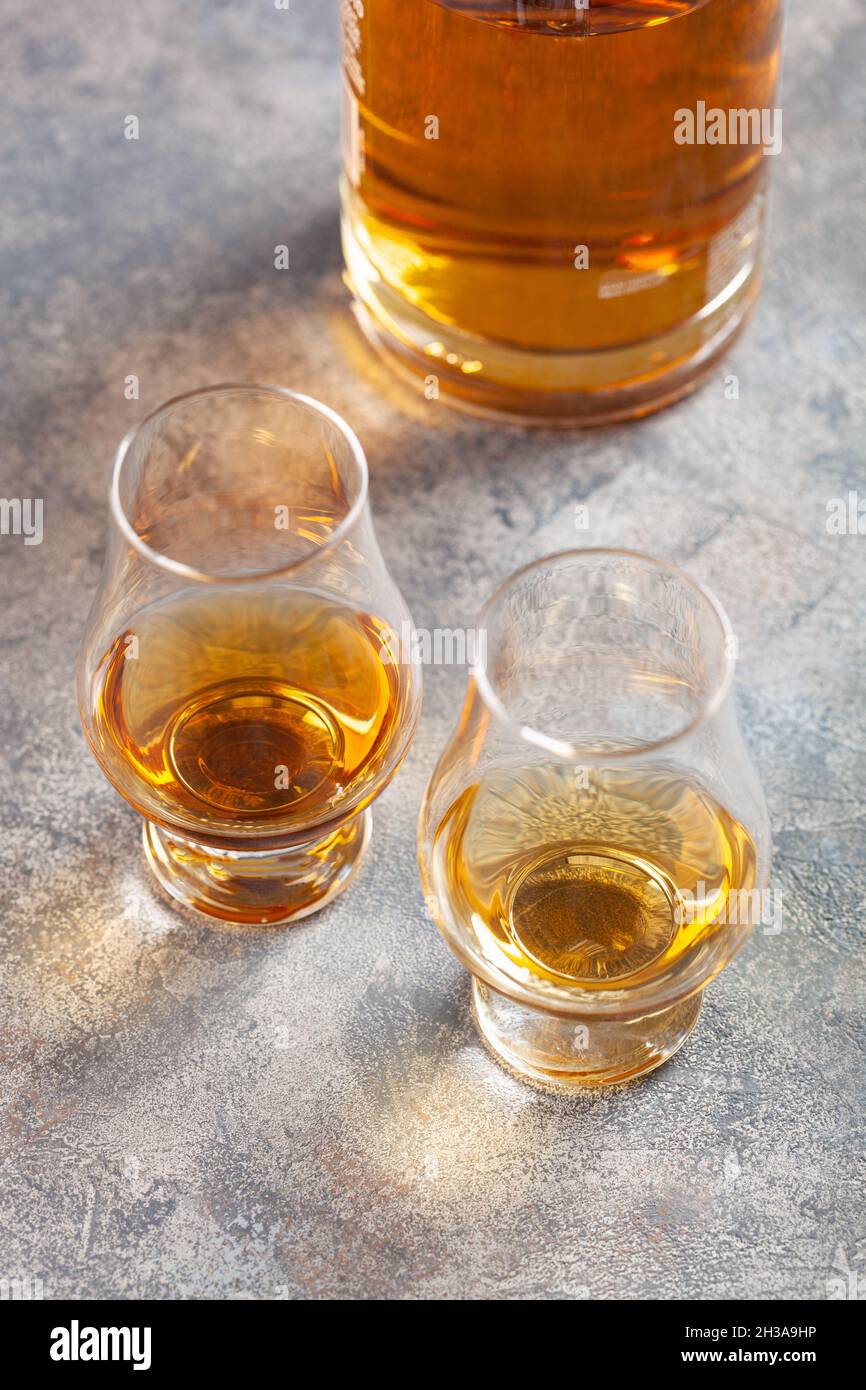 glass and bottle of whisky spirit brandy on gray concrete background ...