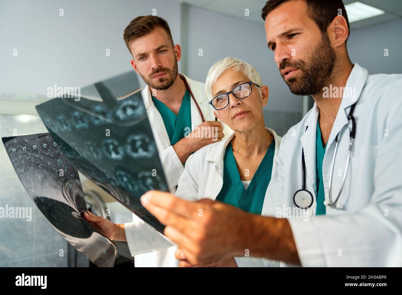 Group of radiology doctor looking at x-ray and discussing it Stock ...