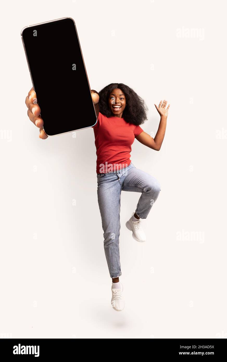 Mobile Ad. Cheerful Black Lady Jumping And Holding Big Blank Smartphone ...
