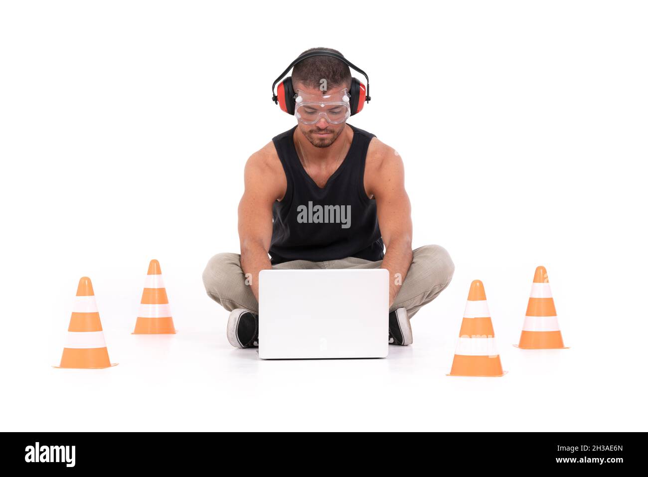 Constructor man working with a laptop within a delimited area with ...