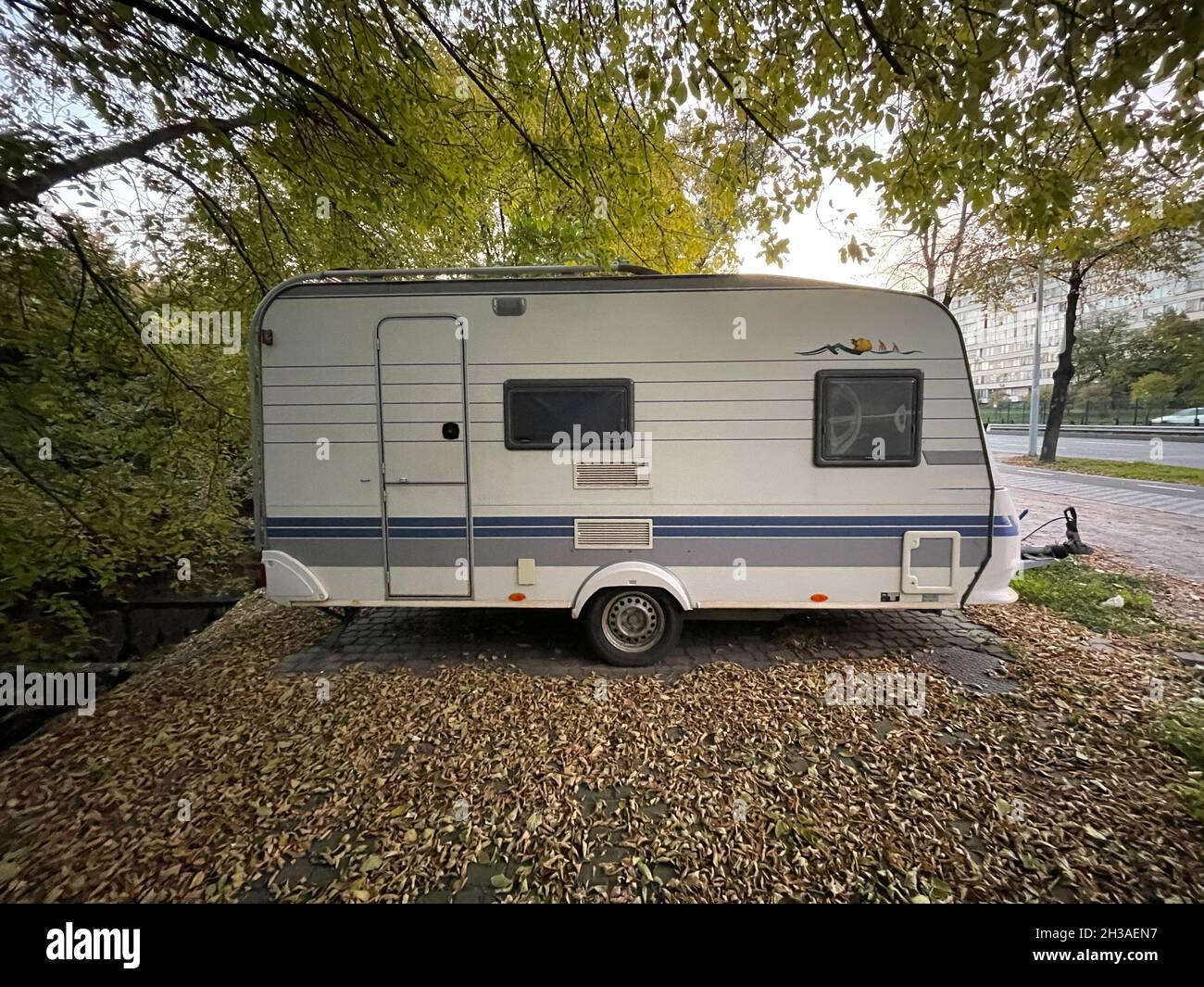 RV camping trailer parked under the tree Stock Photo - Alamy