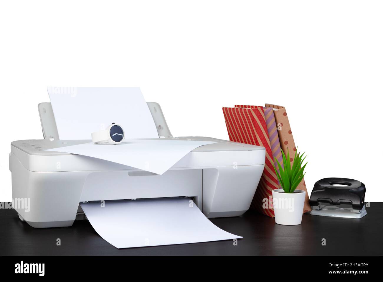Printer and stack of books on black table against white background ...