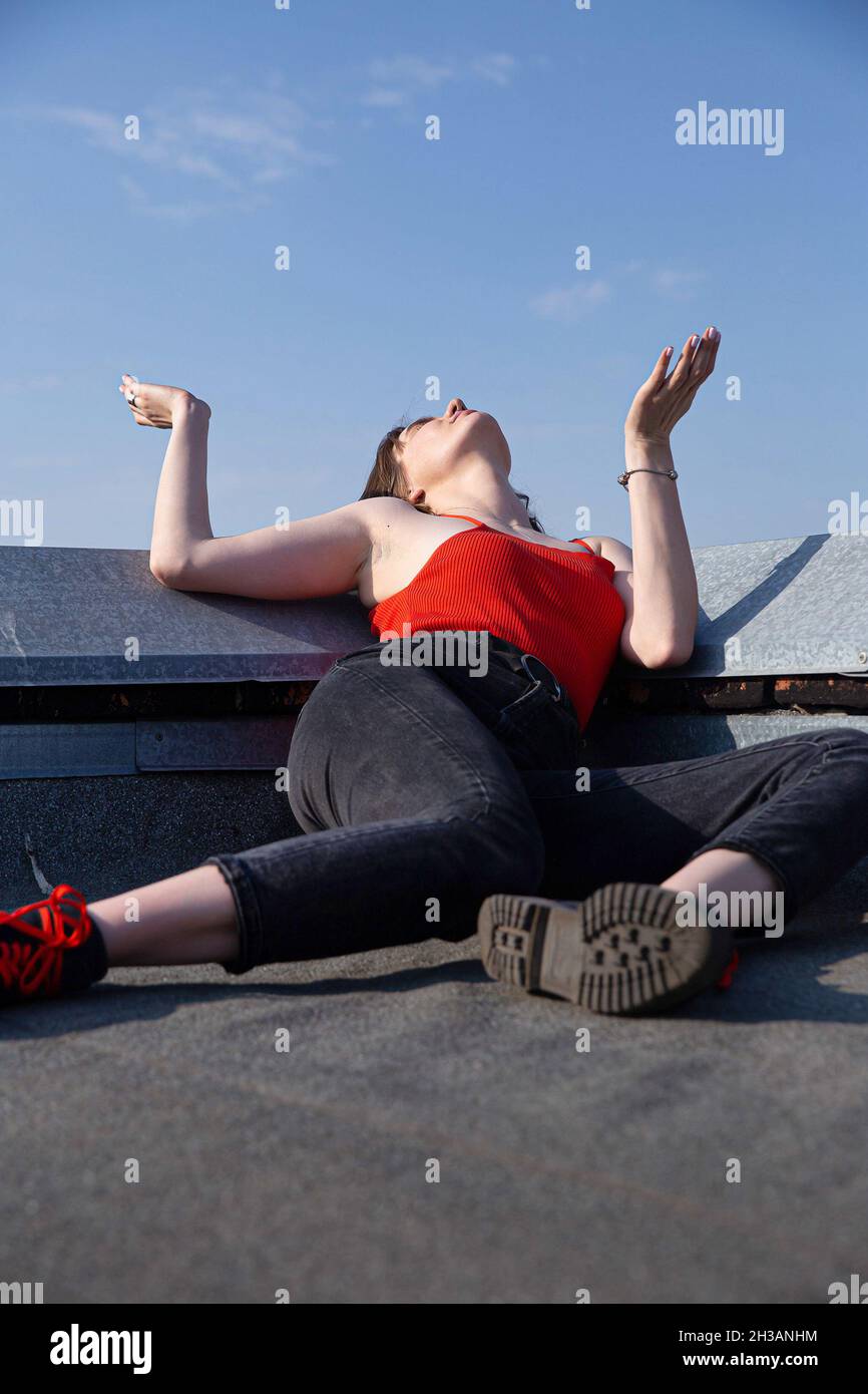 Looking up young white european woman with dark hair on the roof with ...