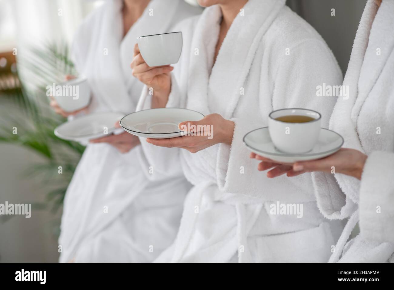 Female hands with cups and saucers Stock Photo - Alamy