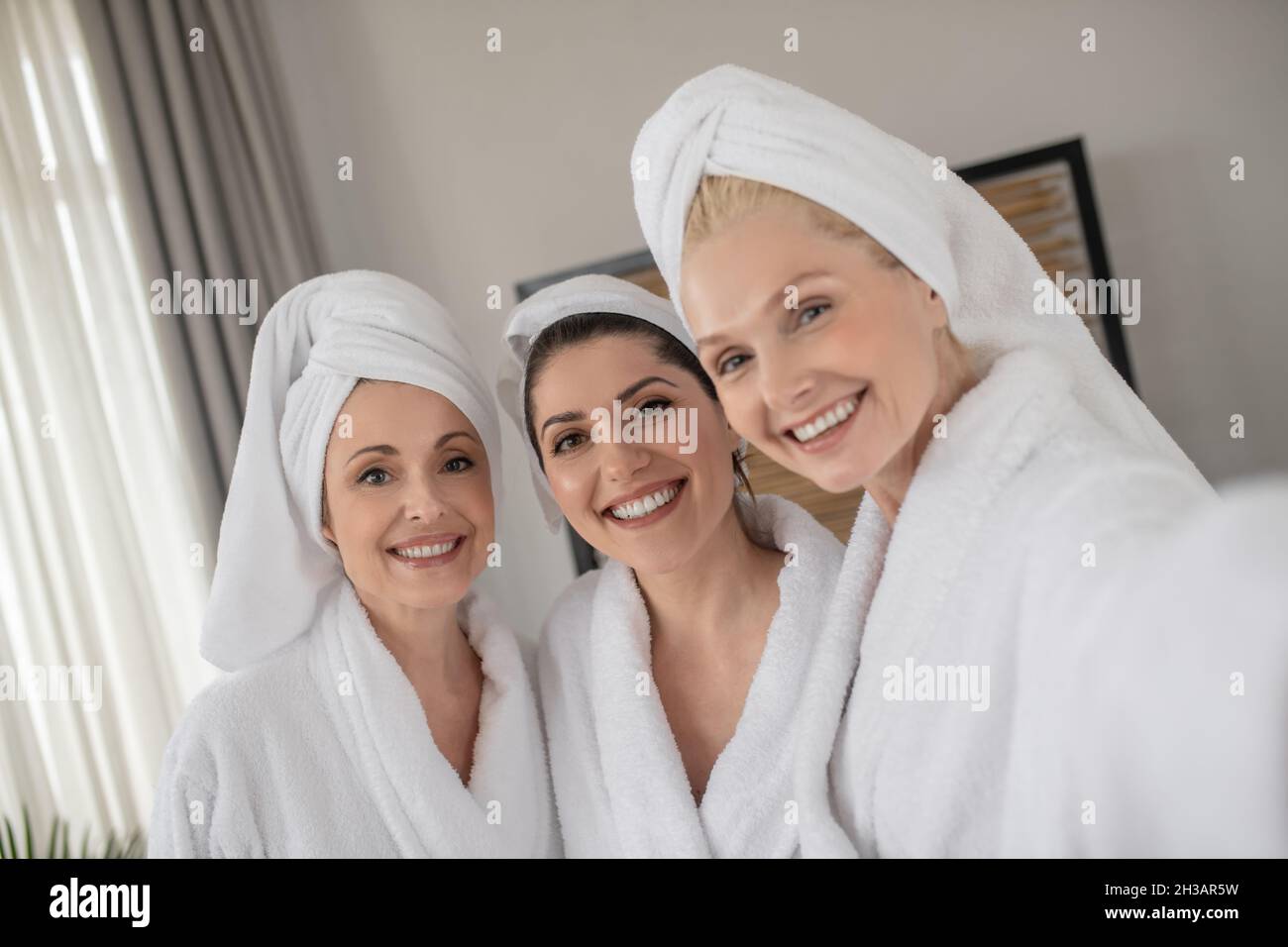 Three charming women with beautiful smile in bathrobes Stock Photo - Alamy