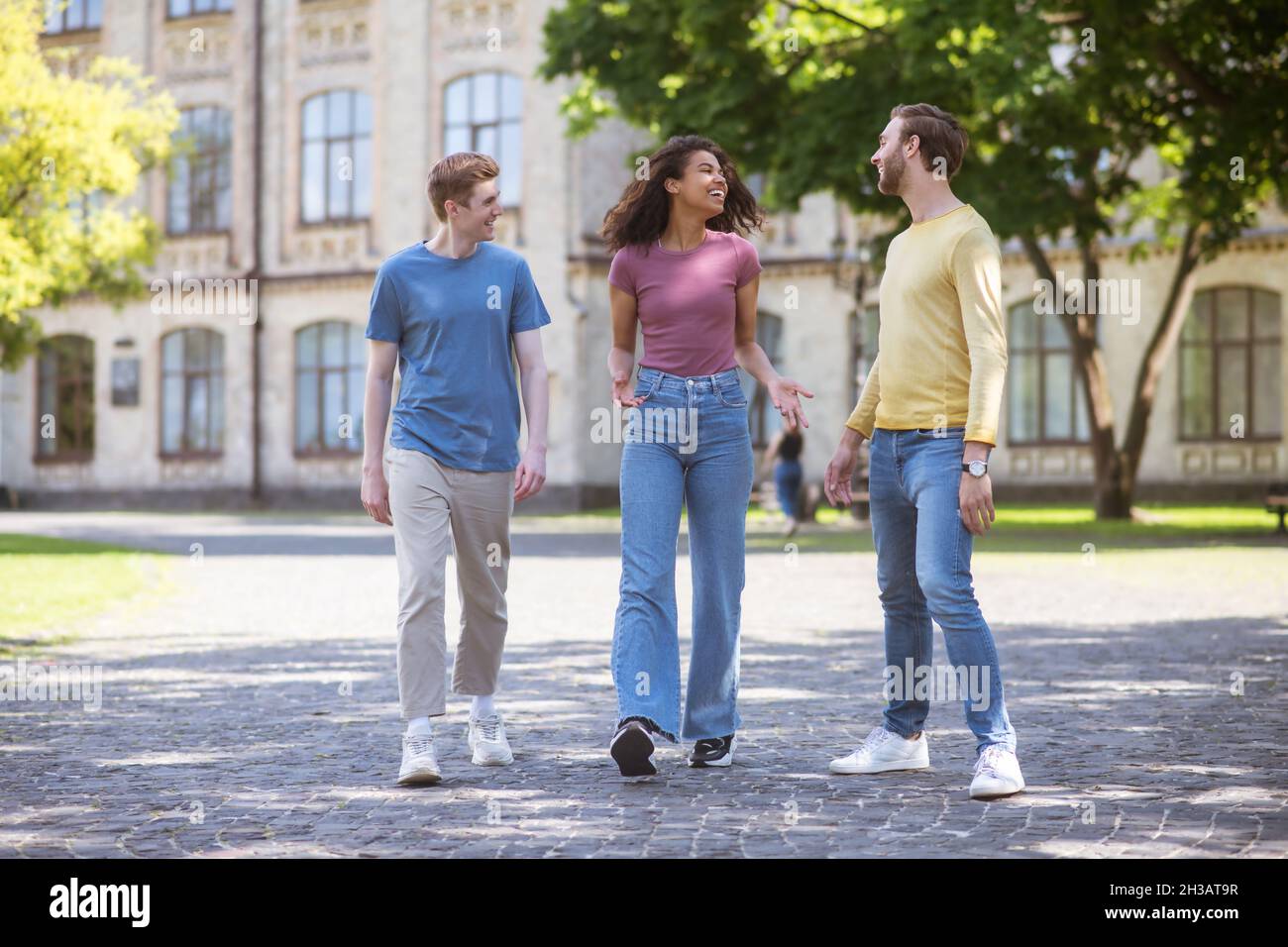 Three people walking in the park and discussing something Stock Photo ...