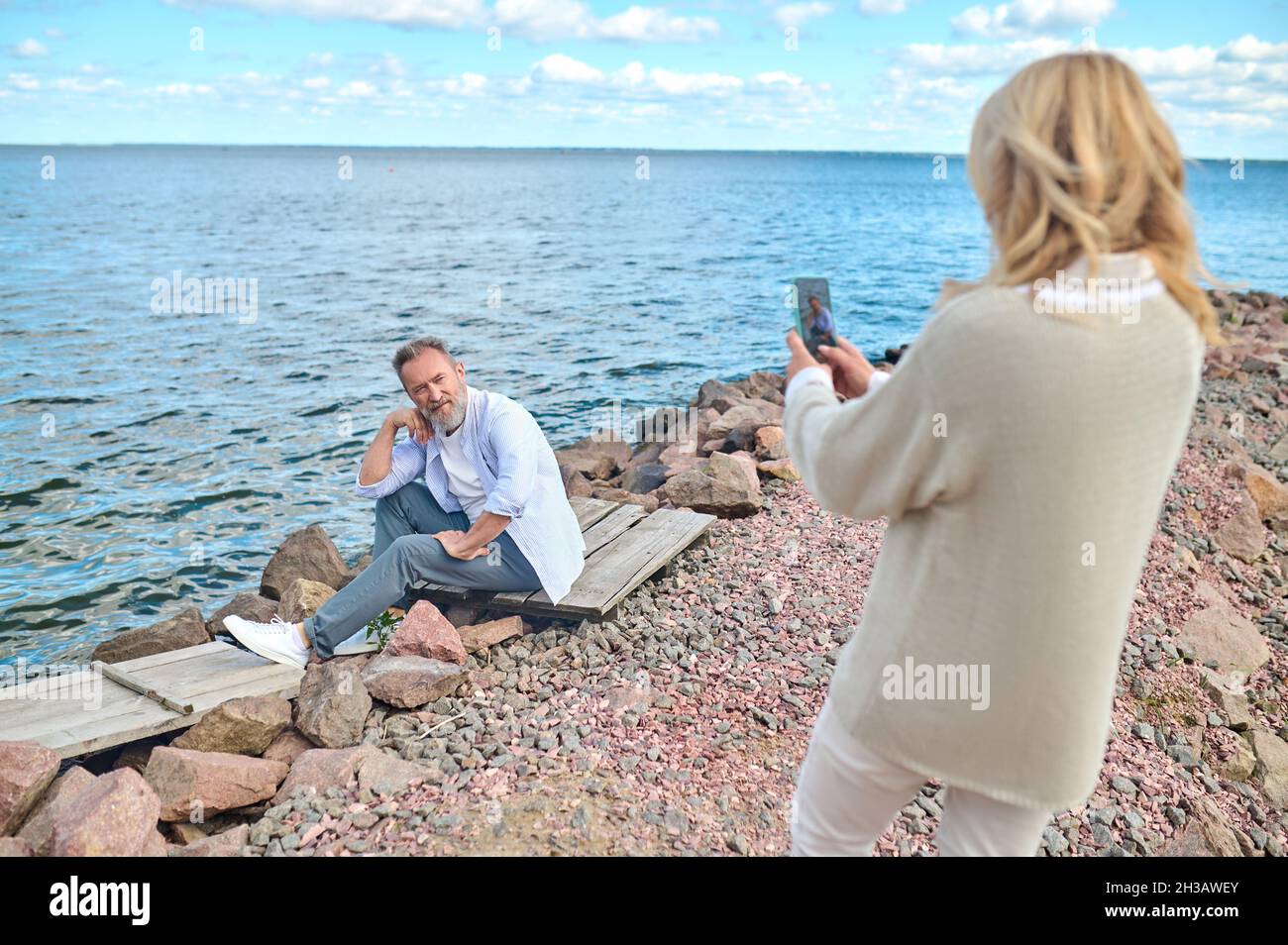 Woman with back to camera photographing man Stock Photo - Alamy