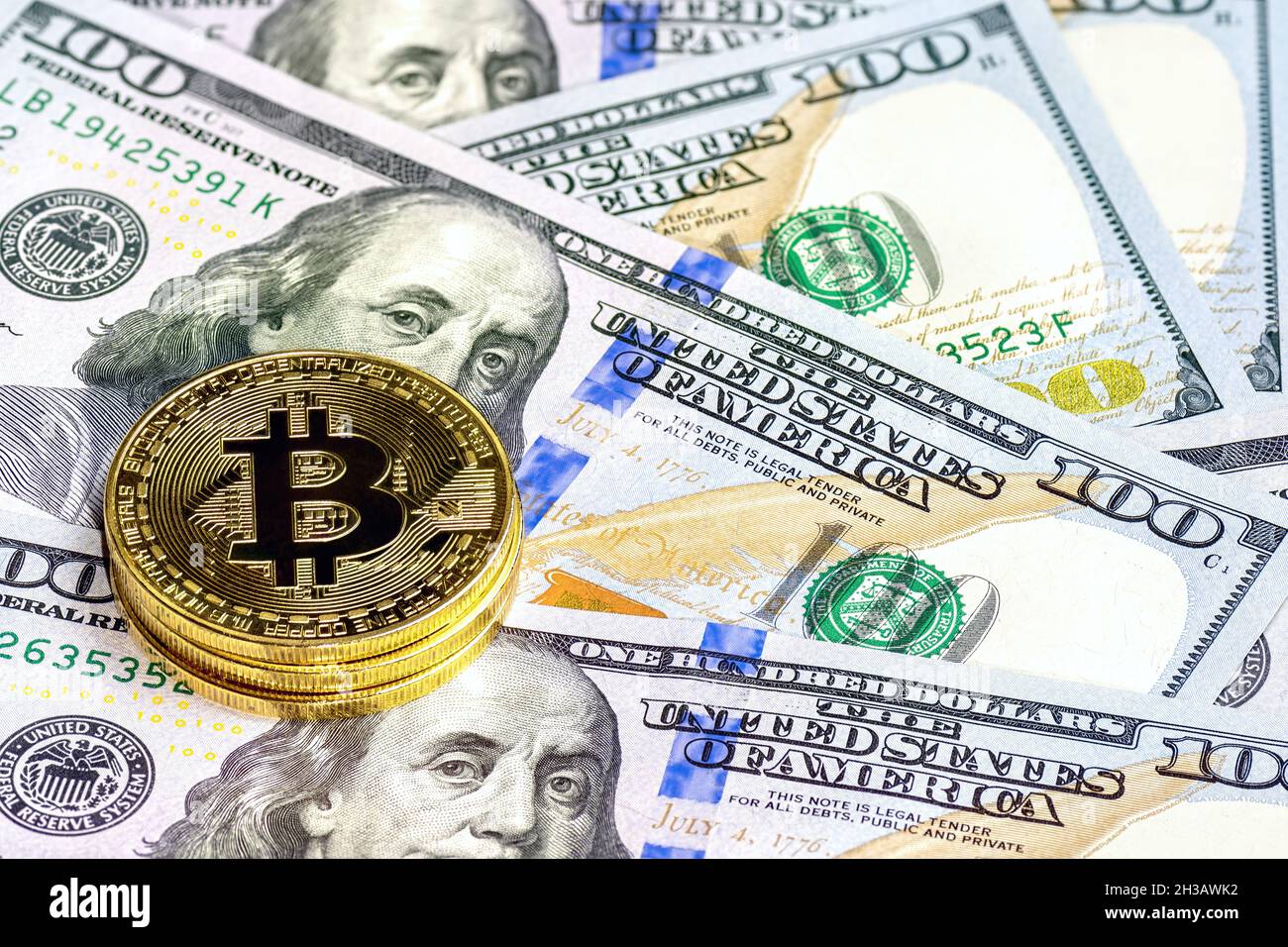 Golden bitcoin coins (BTC) on background of banknotes 100 US dollars ...