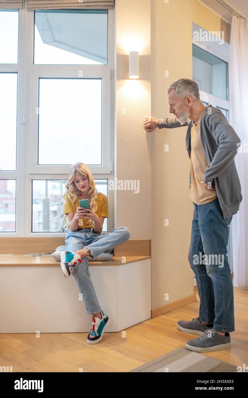 A gray-haired man having a hard talk with his teenage daughter Stock ...