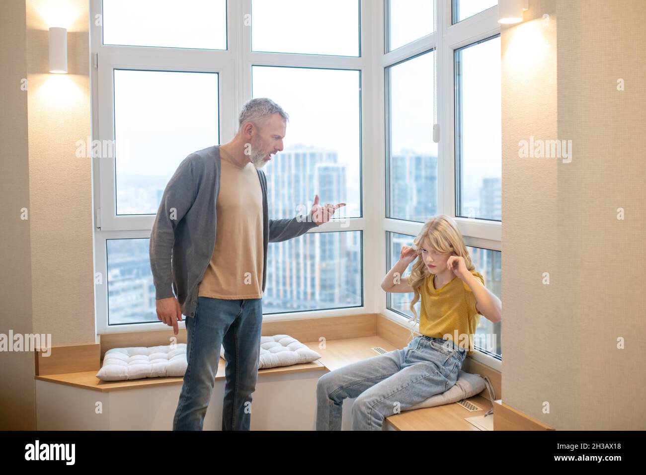 A gray-haired man having a hard talk with his teenage daughter Stock ...
